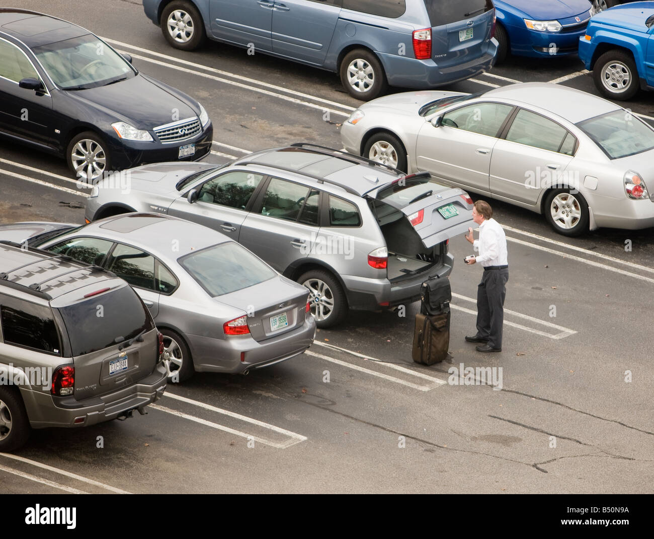 Man taking his bags out of a trunk Stock Photo - Alamy