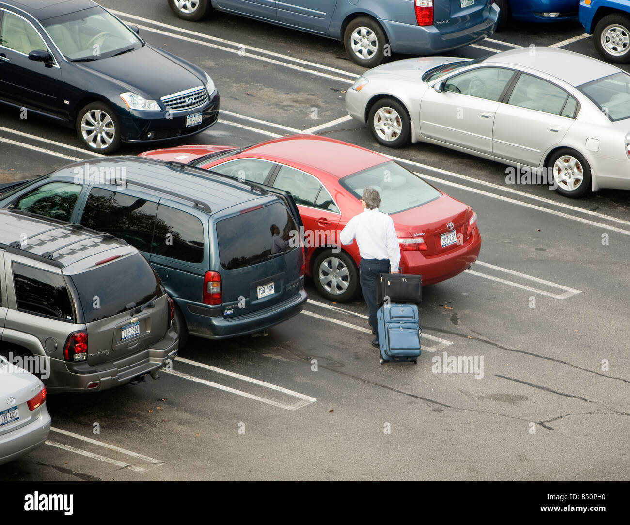 Man using a rolling cart to move his luggage Stock Photo - Alamy