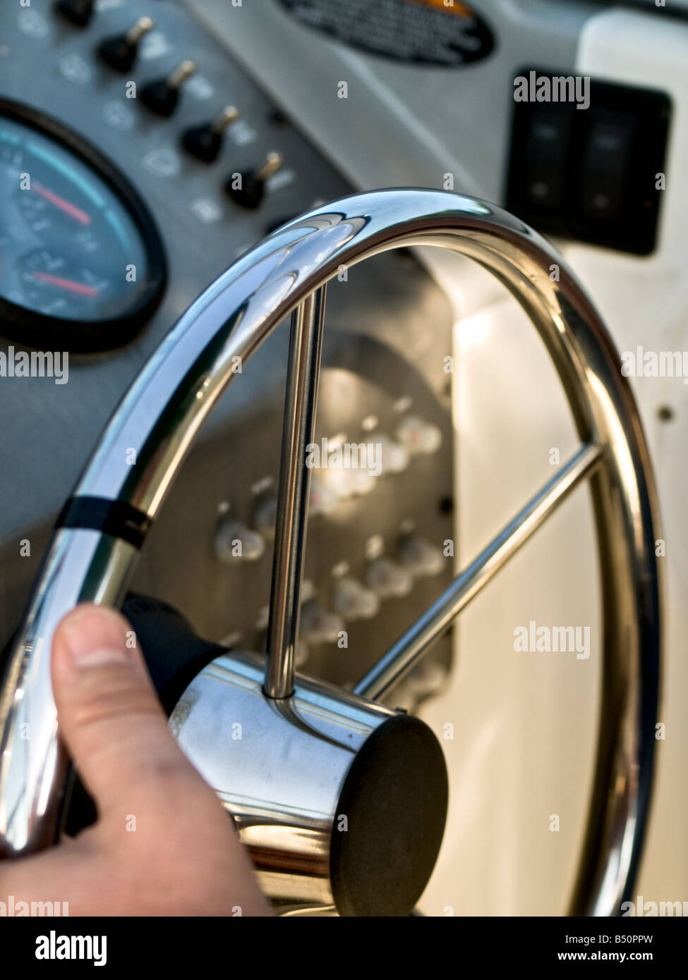 The hand of the ship's captain holding the steering wheel on a boat ...