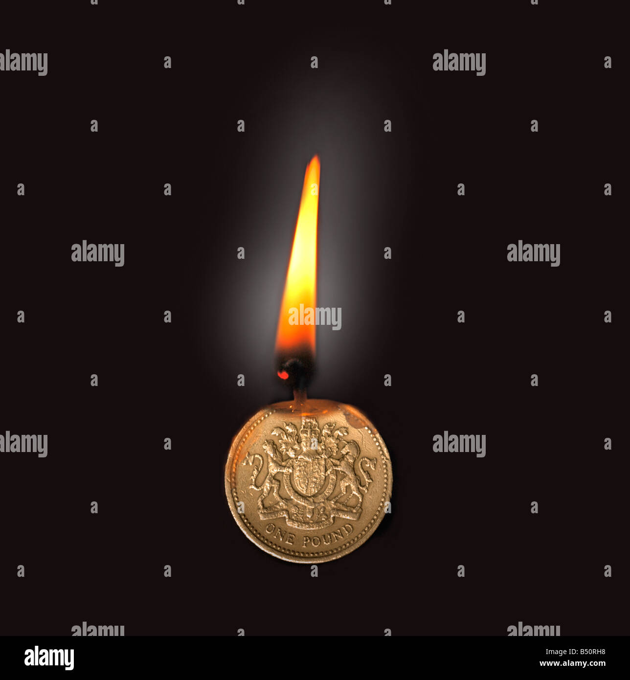 a lit and burning one pound coin - candle shaped Stock Photo - Alamy