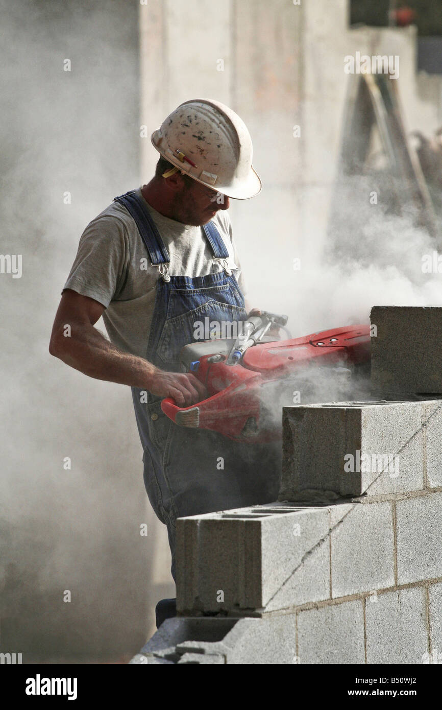 Construction worker with cement block saw and smoke Stock Photo - Alamy