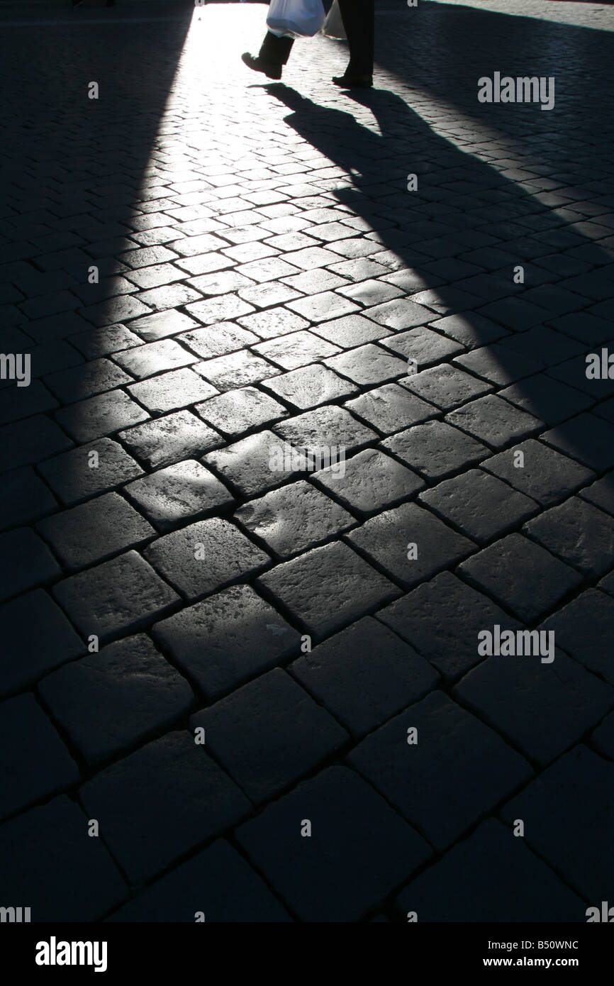 person shadow walking on cobbled street in morning sun Stock Photo - Alamy