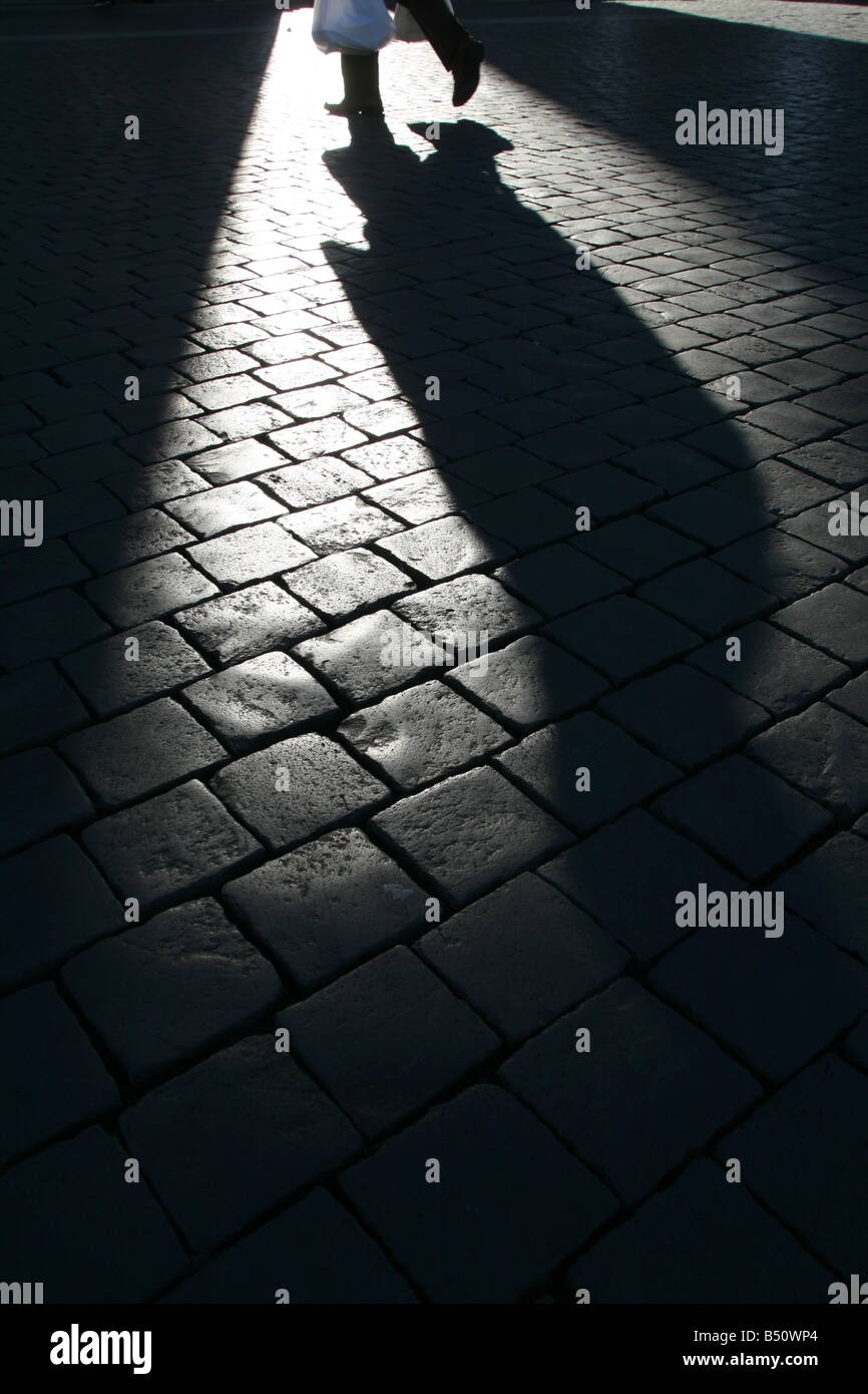 person shadow walking on cobbled street in morning sun Stock Photo - Alamy