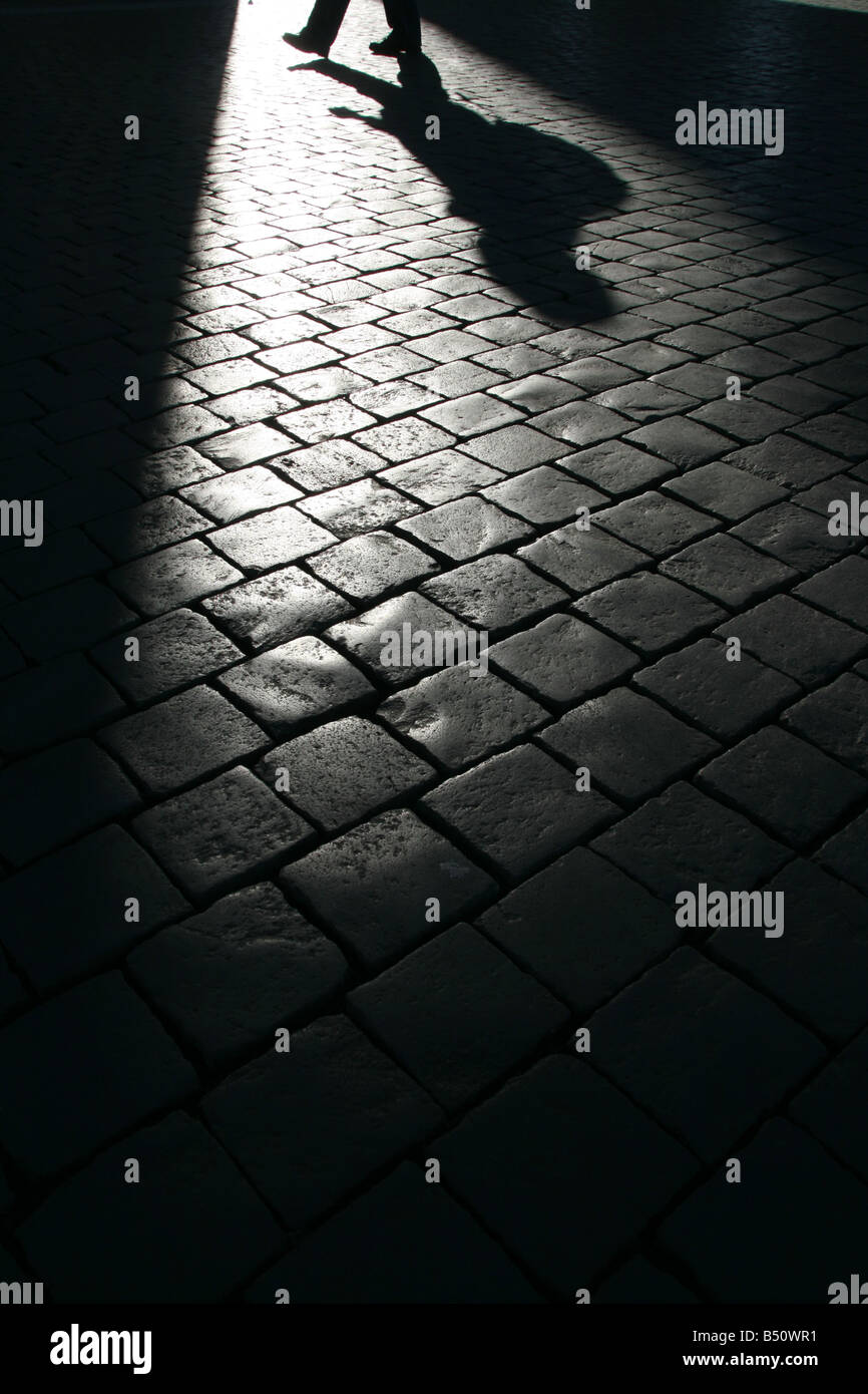 person shadow walking on cobbled street in morning sun Stock Photo - Alamy