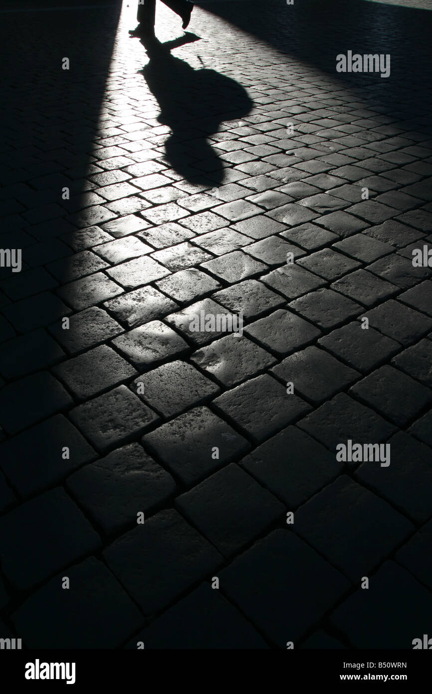 person shadow walking on cobbled street in morning sun Stock Photo - Alamy
