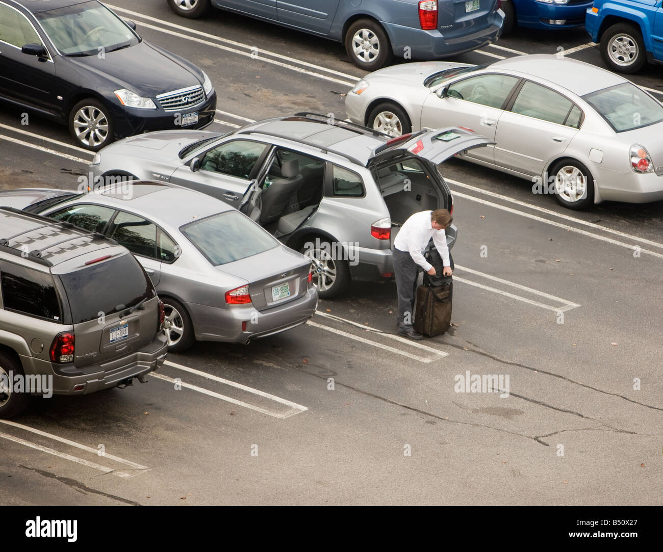 Man getting ready to put luggage into his car Stock Photo - Alamy
