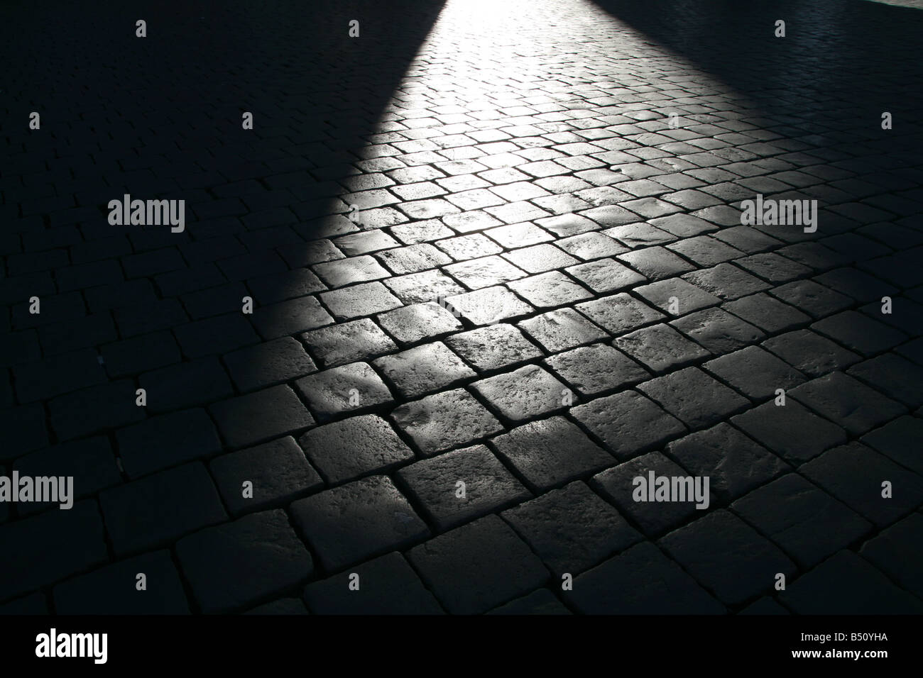 arch shadow on empty cobbled street in morning sun Stock Photo - Alamy
