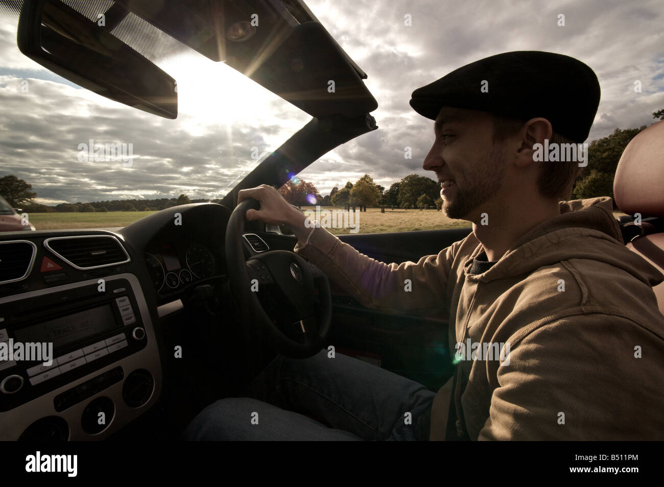 Man driving convertible car in sunshine Stock Photo - Alamy
