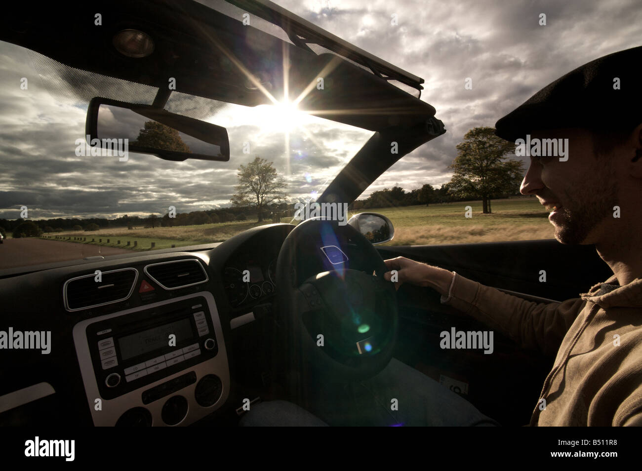 Man driving convertible car in sunshine Stock Photo - Alamy