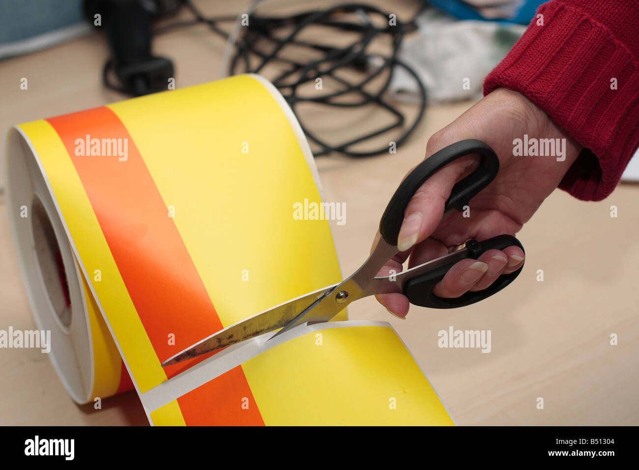 Woman is cutting a label with scissors Stock Photo - Alamy