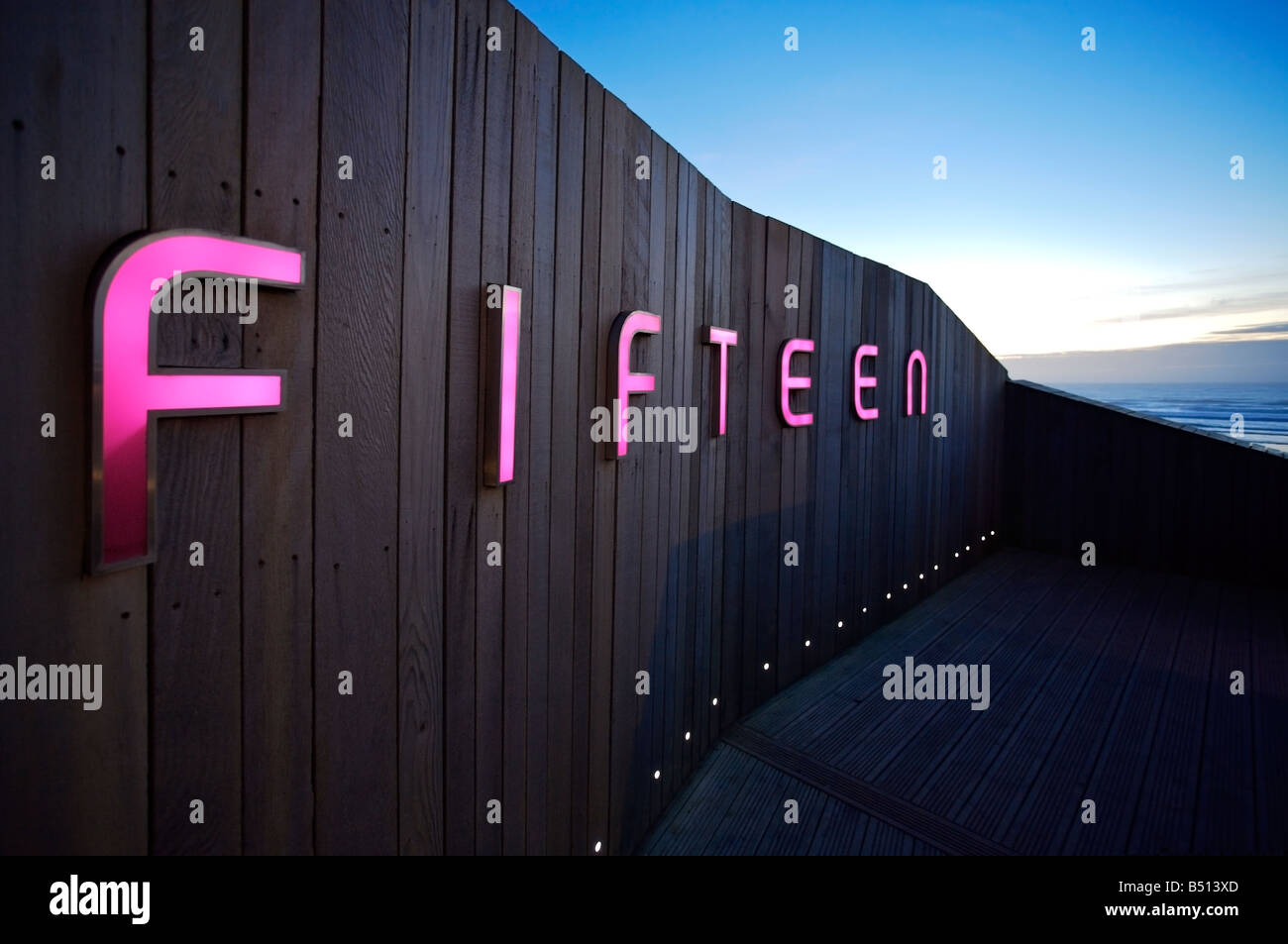 Illuminated sign above the beach at Fifteen Cornwall, Watergate bay ...