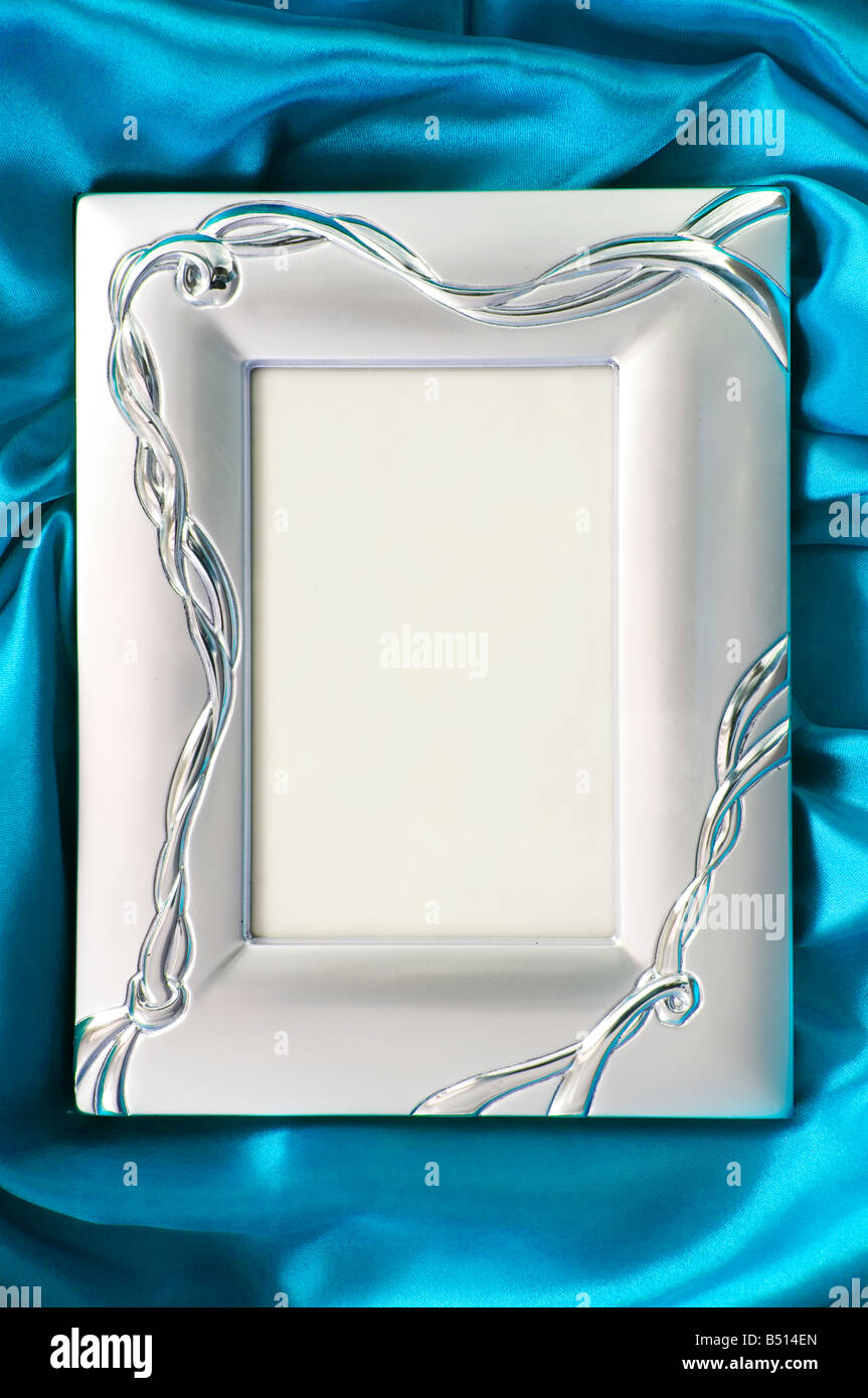 Silver picture frame on blue satin Stock Photo - Alamy