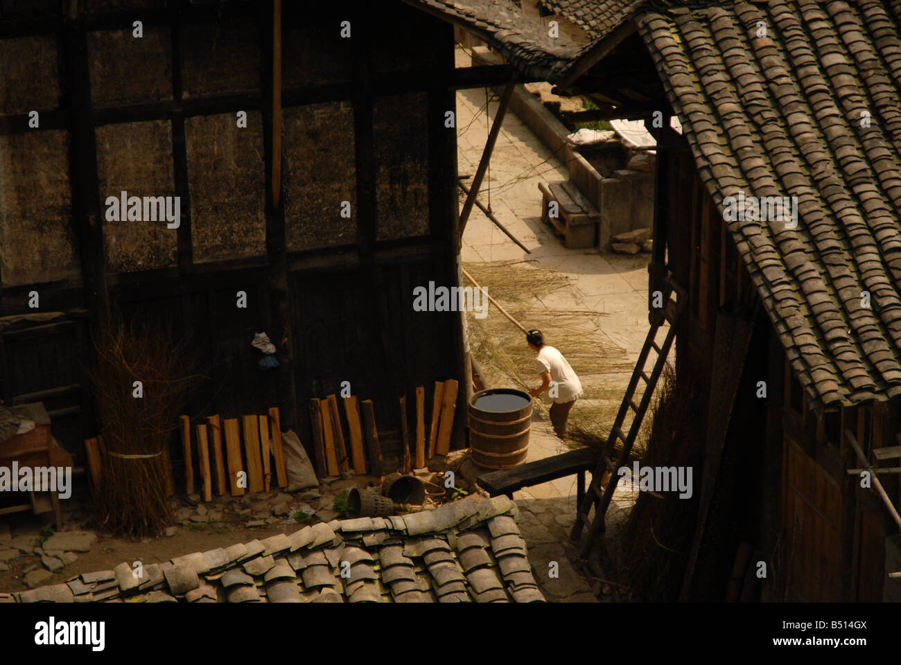 A woman lays herbs to dry in an ancient courtyard in rural Chongqing ...