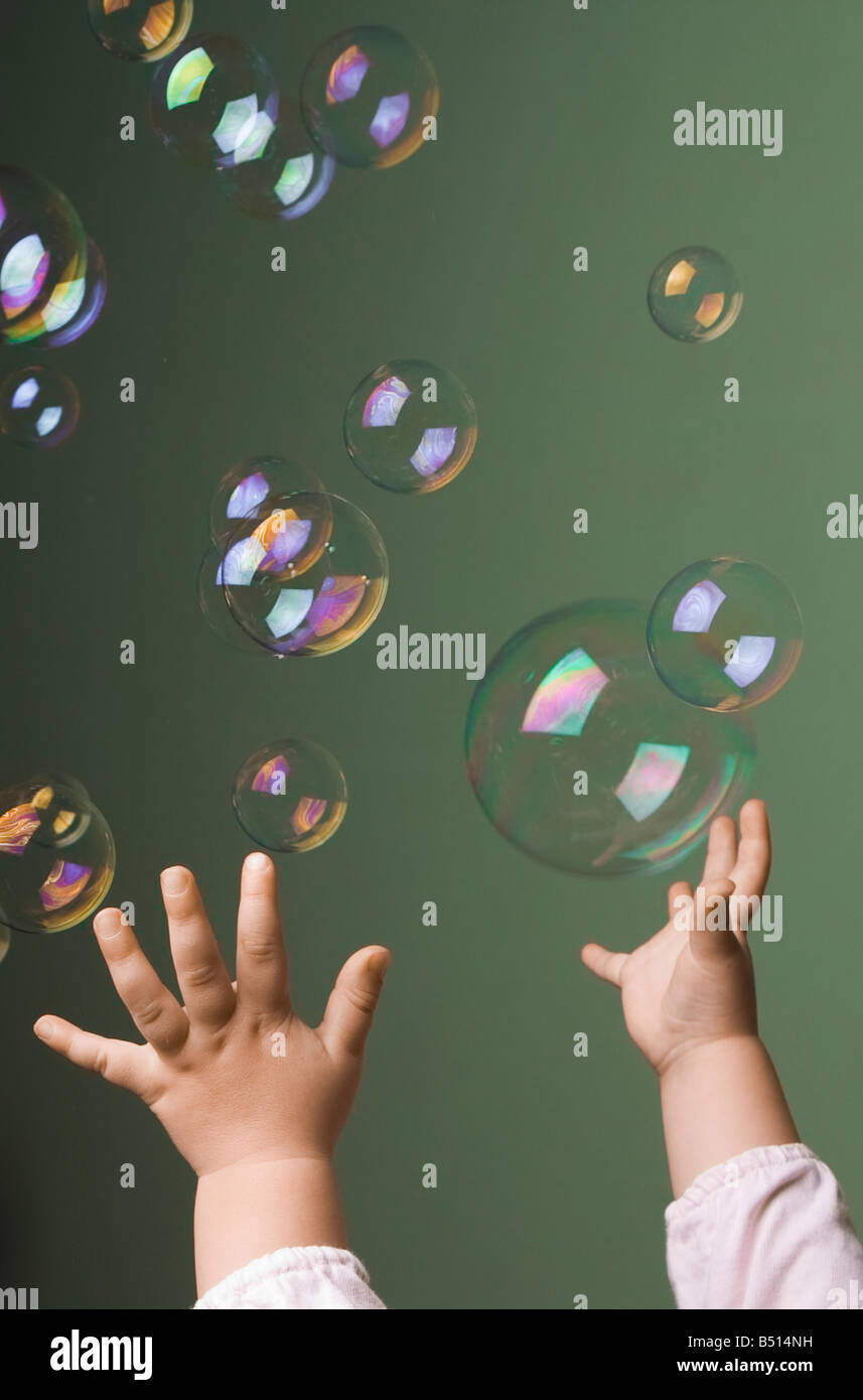 Baby hands trying to catch soap bubbles Stock Photo - Alamy