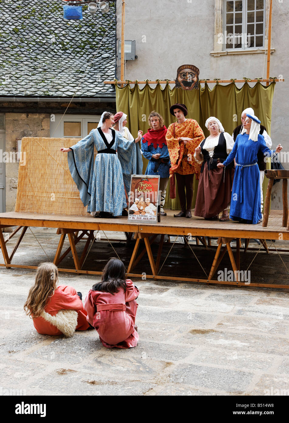 Children dressend in Medieval costumes watch a French play in Estaing ...