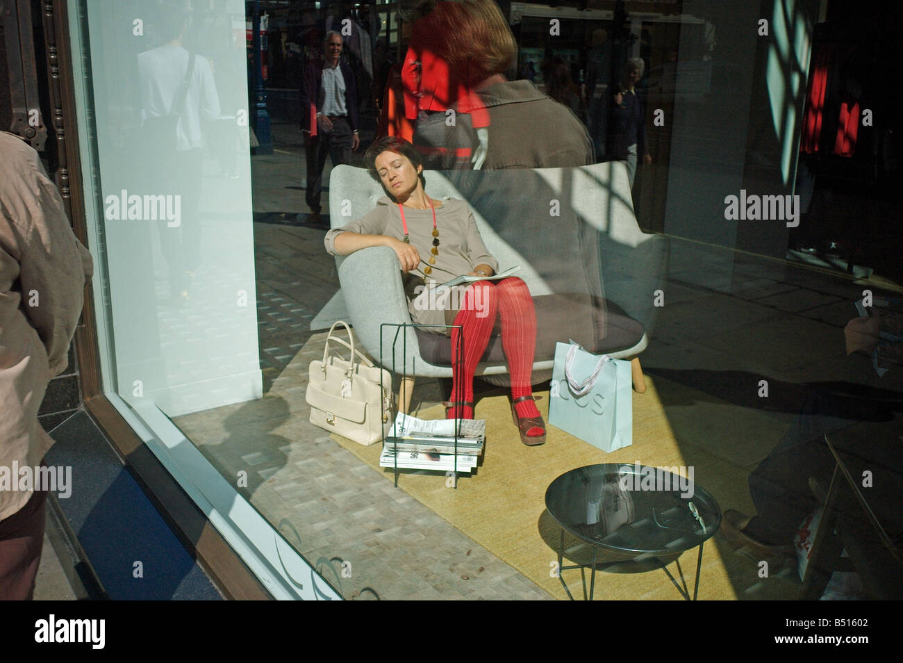 A shopper resting on a settee in a waiting area of a shop on Londons ...
