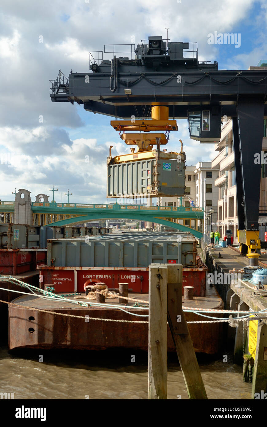 Shipping containers loading onto barge on the Thames in City of London ...