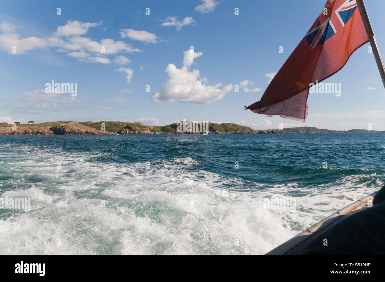 The Red Ensign or "Red Duster" seen against a blue sky over the wake of ...