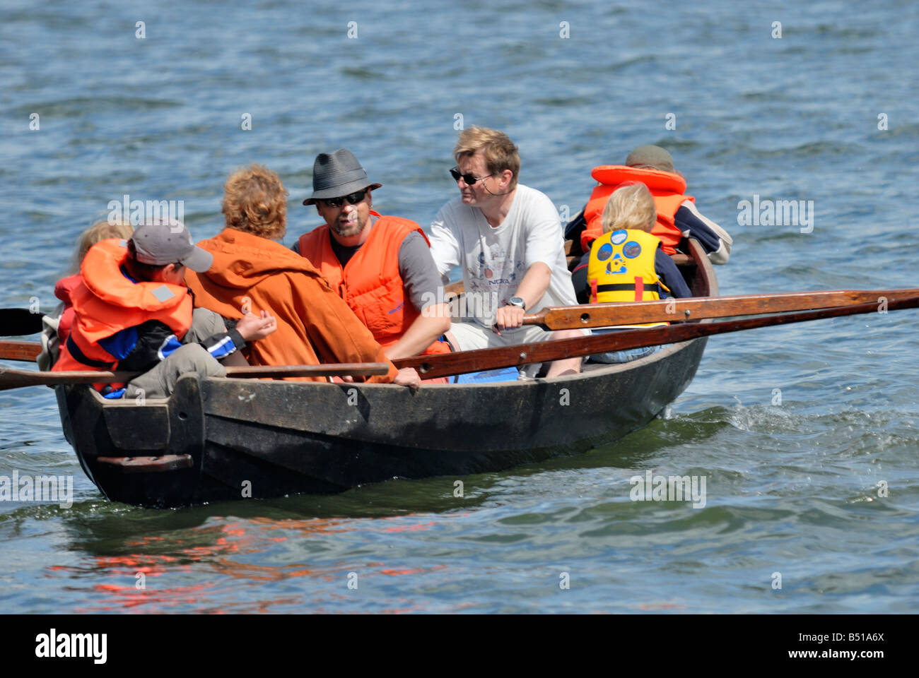 Two families in a two oar row boat on the Baltic sea, Porvoo, Finland ...