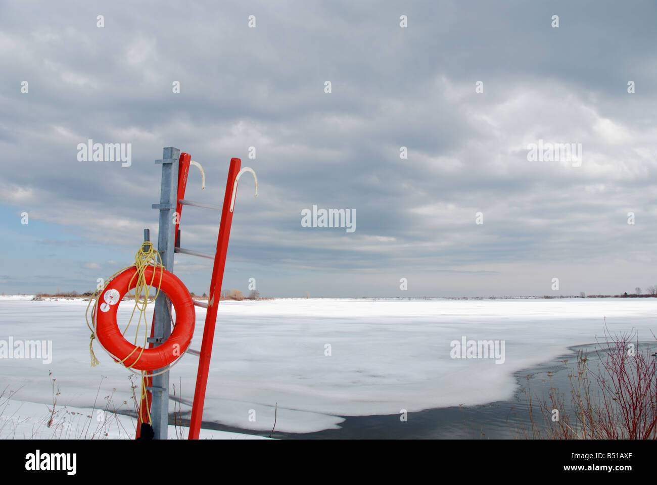A red life preserver and rescue ladder on the shore of Lake Ontario ...
