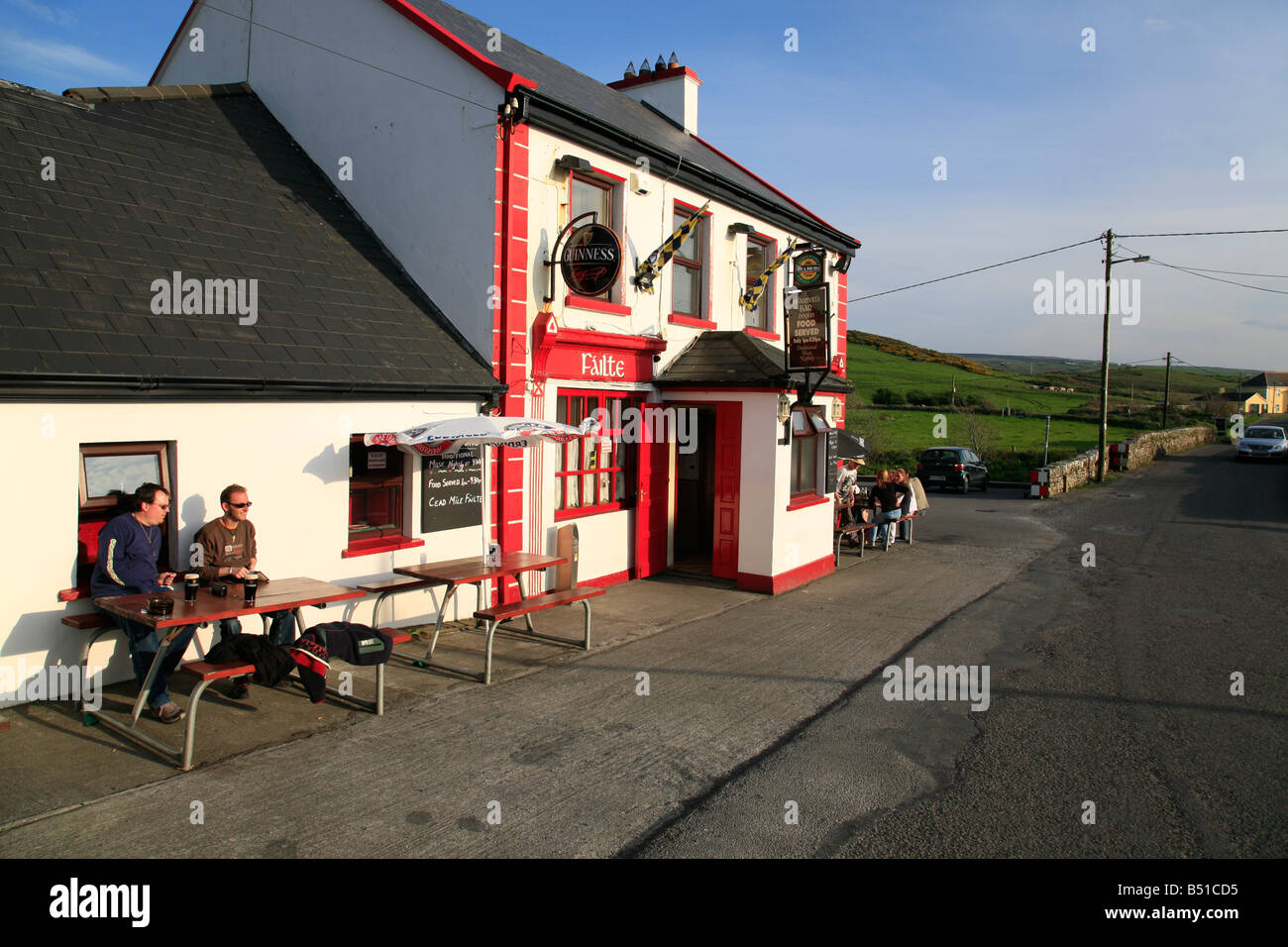 two men drink Guinness in front of the bar McDermott's in Doolin the ...
