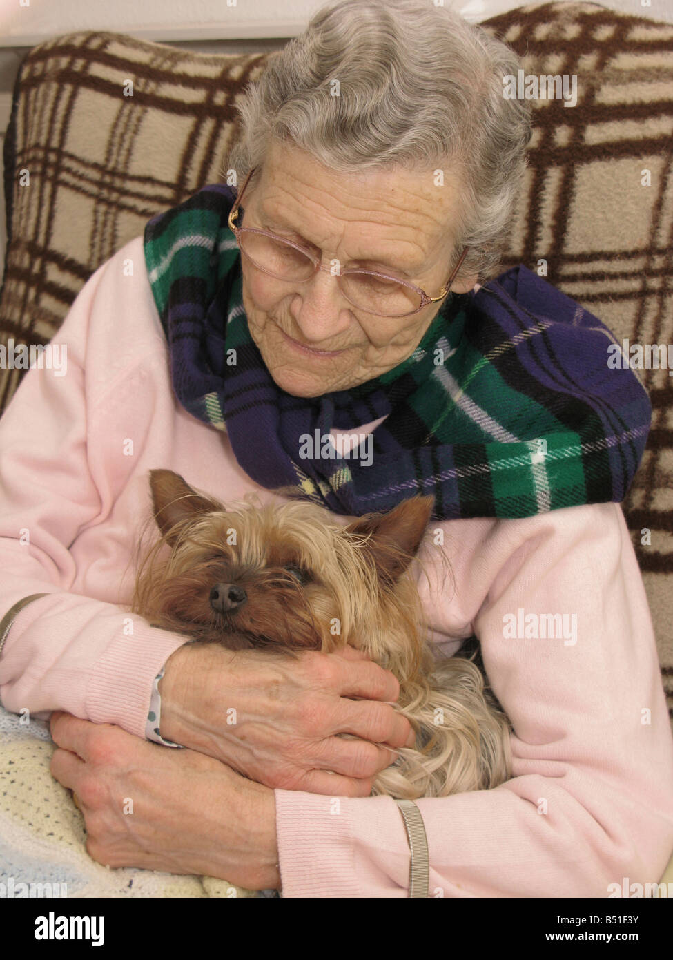 elderly woman keeping warm in winter wrapped up with rugs to save ...