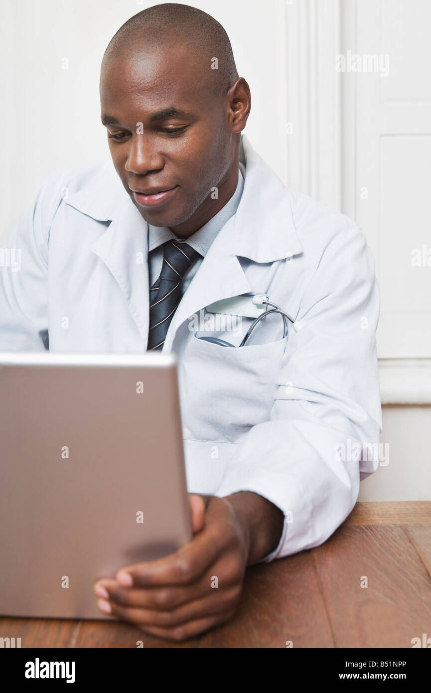 Physician Sitting Behind Desk Working on Laptop Stock Photo - Alamy