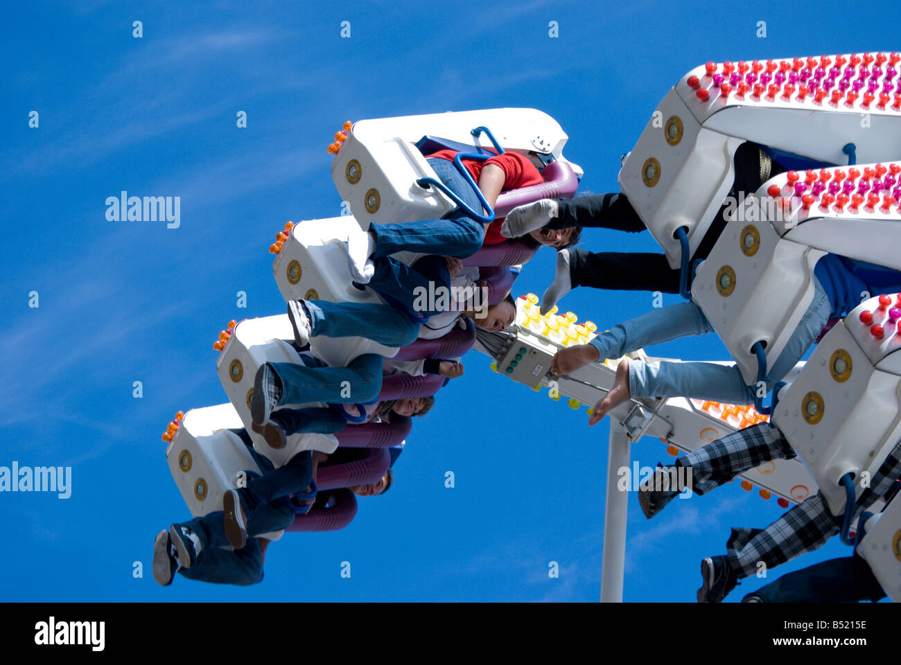 High speed thrilling carnival ride on brilliant blue sky background ...