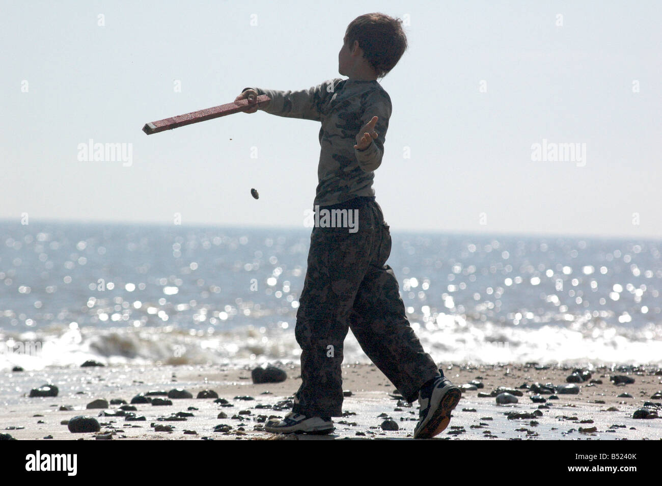 Boy Throwing Pebbles Into The Sea High Resolution Stock Photography and ...