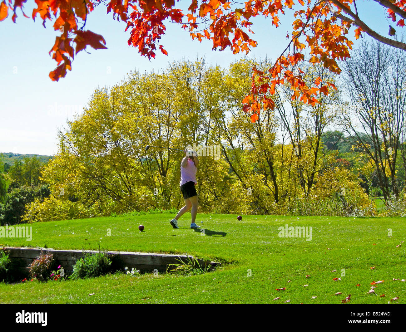 Woman playing golf in autumn Stock Photo - Alamy