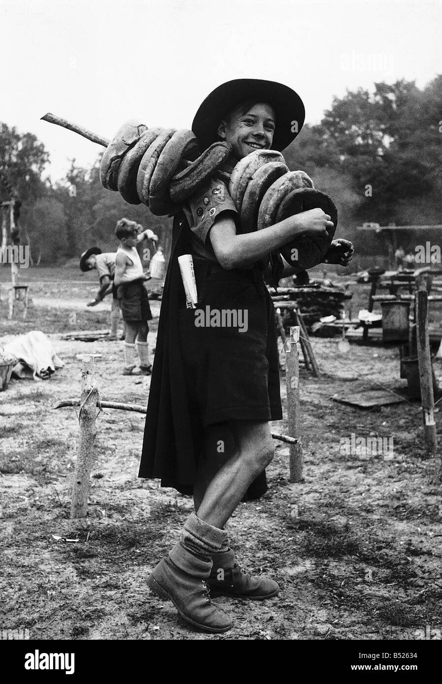A scout is carrying holed bread with a pole through the centre of them ...