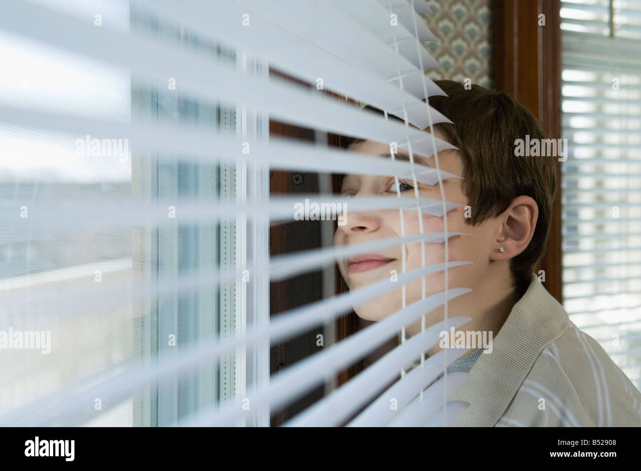 Boy standing near window Stock Photo - Alamy