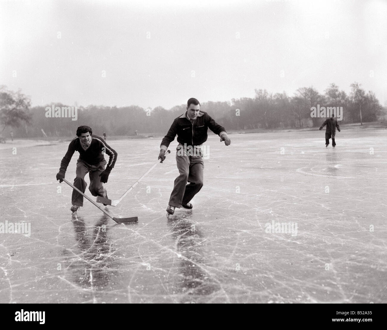 Weather Winter Scenes 1954 Two boys playing ice hockey on a frozen lake ...