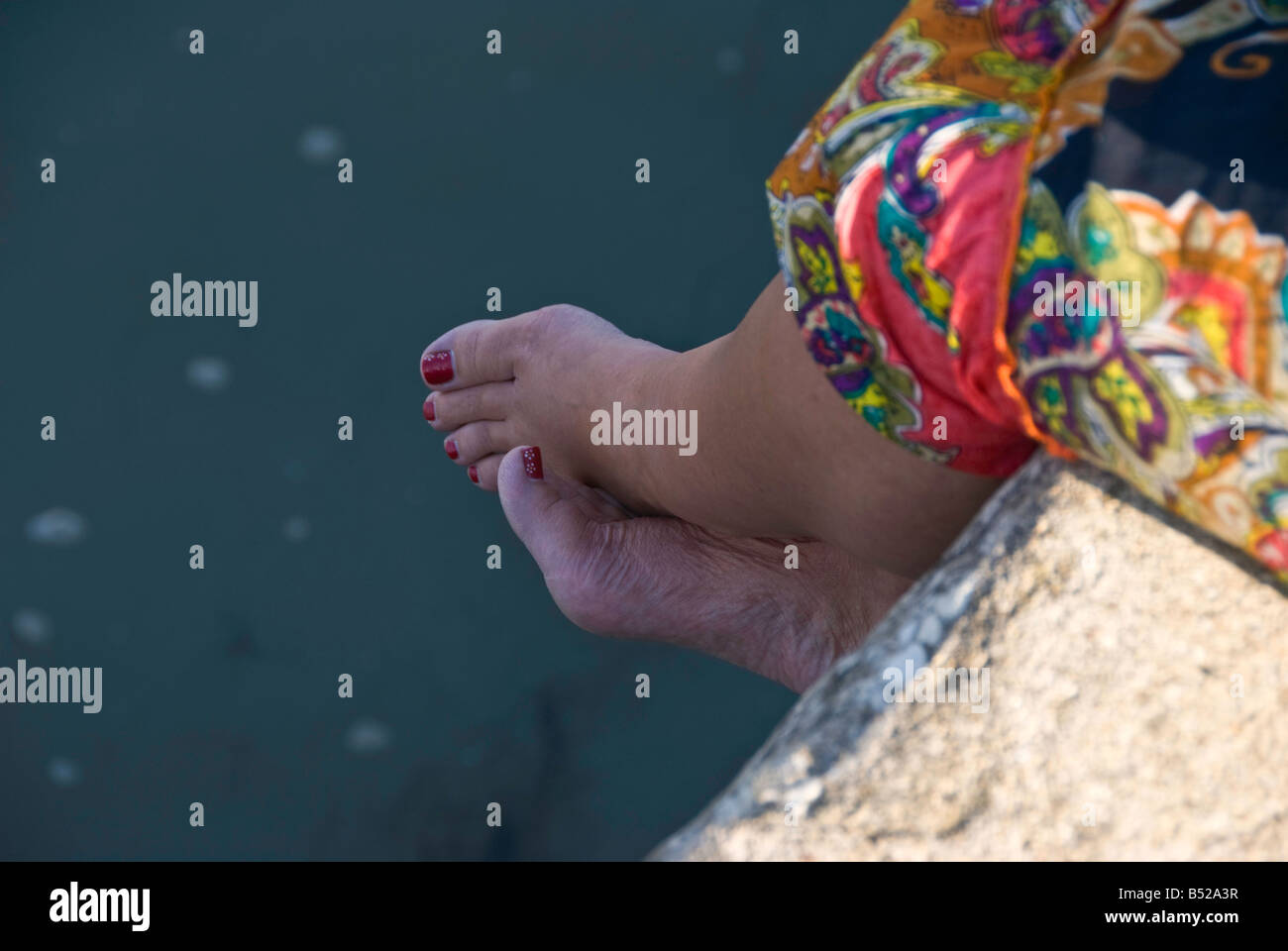 Feet at rest overhanging a waterway Stock Photo - Alamy