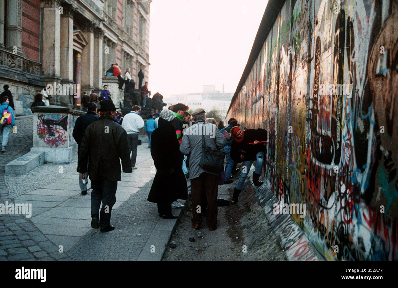 Berlin Wall in Germany with people chipping bits off the wall for ...