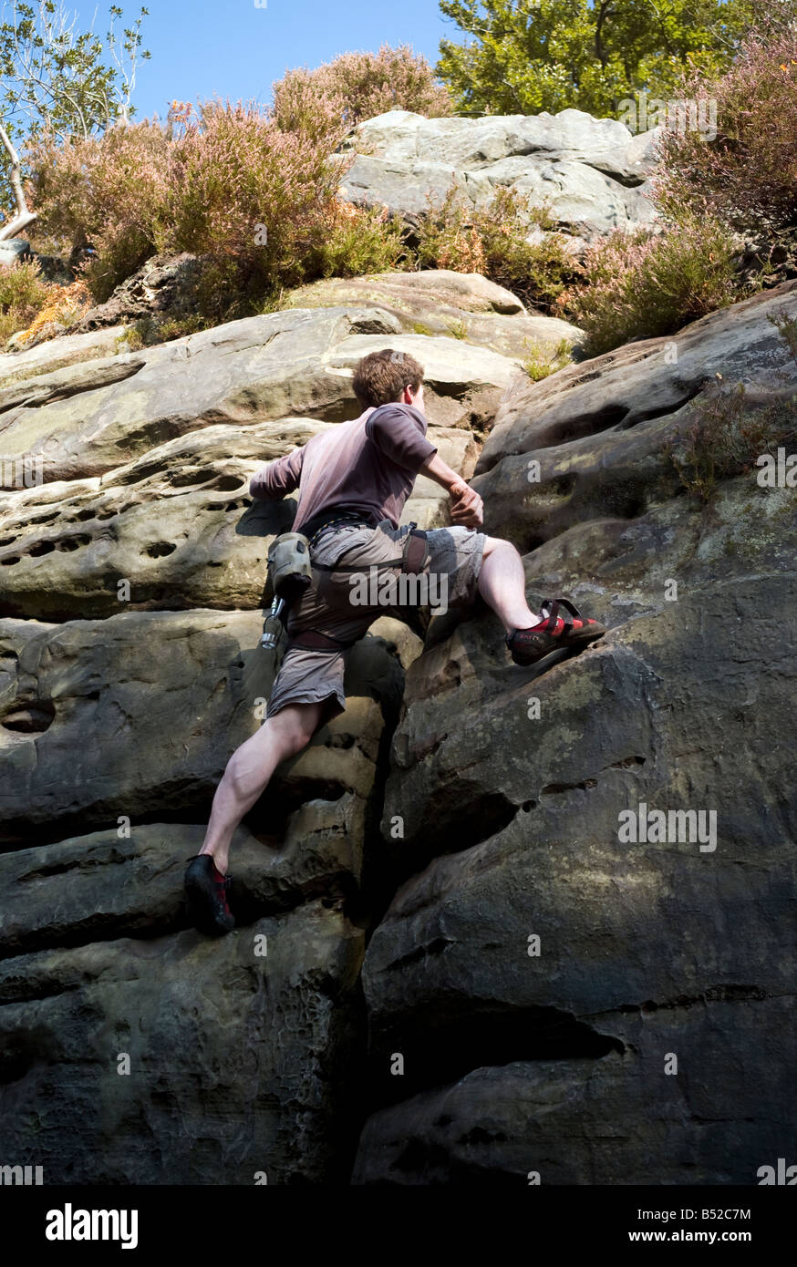 Young man climbing solo up sandstone crag, Harrisons Rocks, near ...