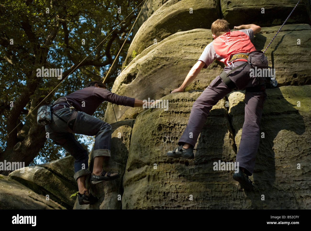 Two young men climbing on sandstone crag, Harrisons Rocks, Sussex Stock ...