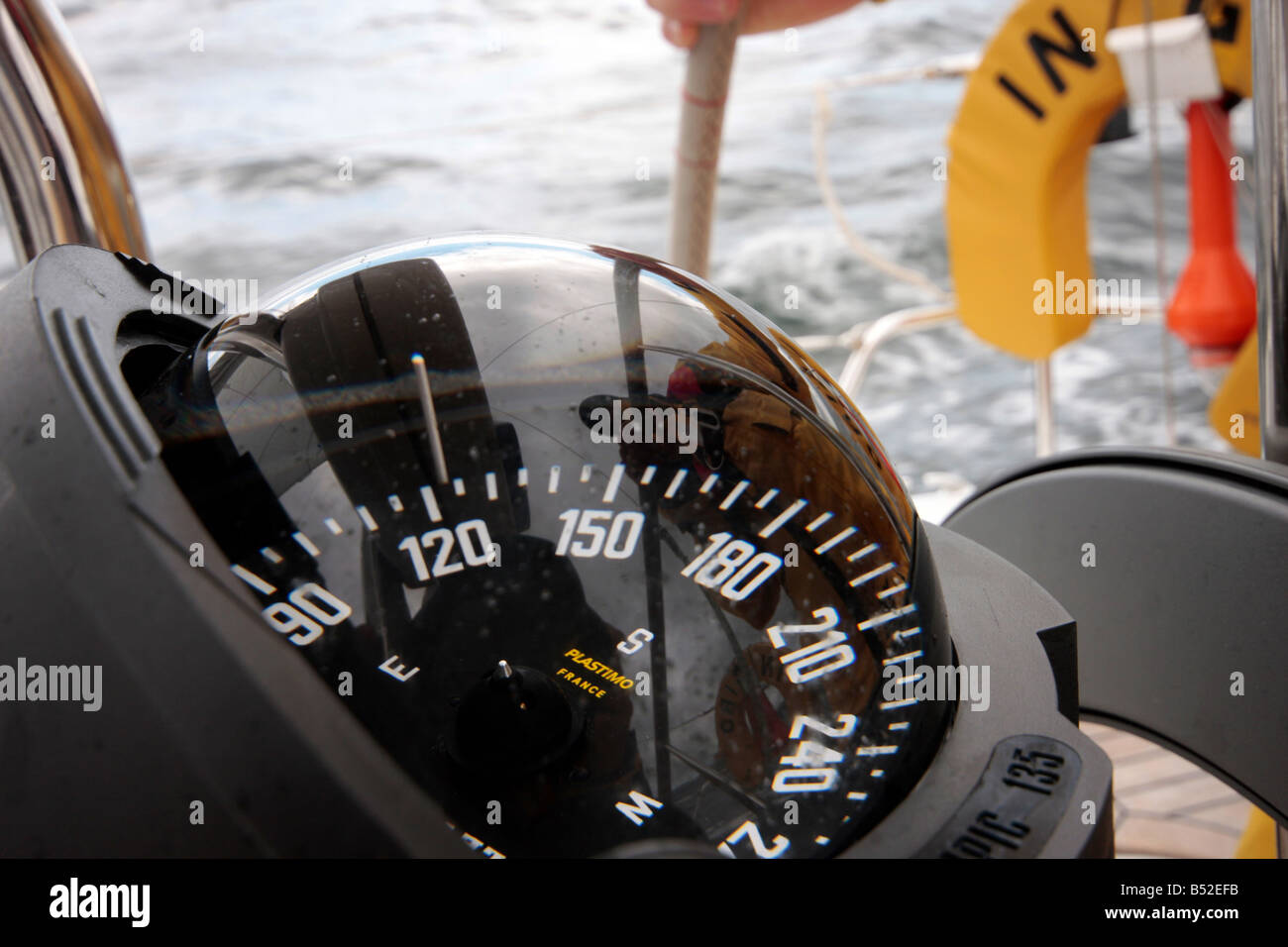 compass on a yacht with reflection of man at helm Stock Photo - Alamy