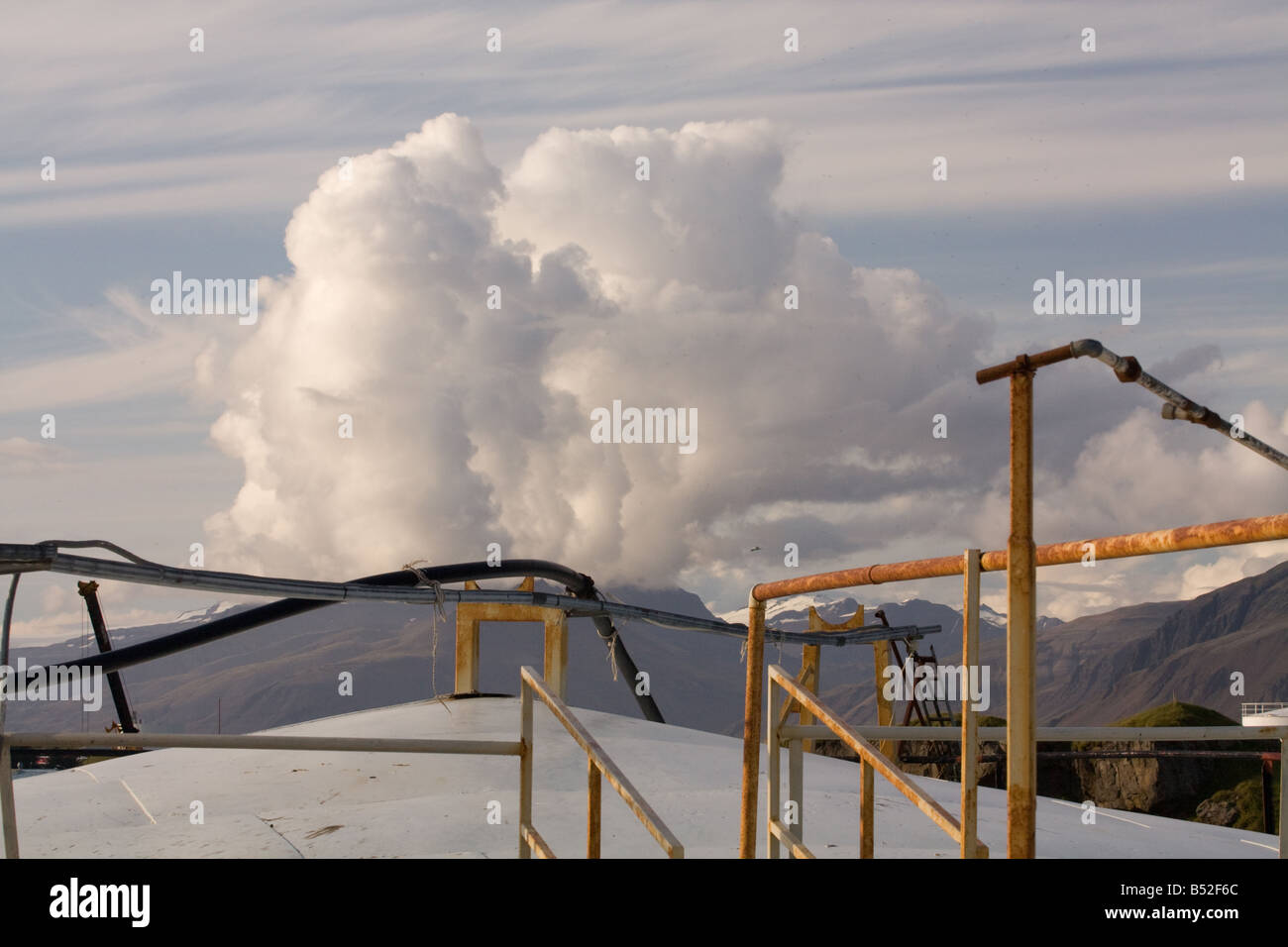Composition of rusty industry and a mountain with a cloud's "eruption ...