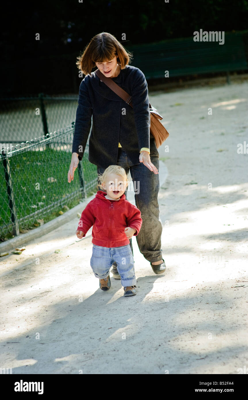 Young mother walking behind her young son ready to catch him if he ...