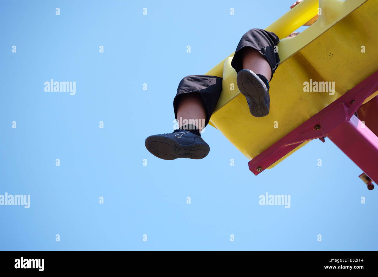 A child's legs dangling from a ride at an amusement park Stock Photo ...