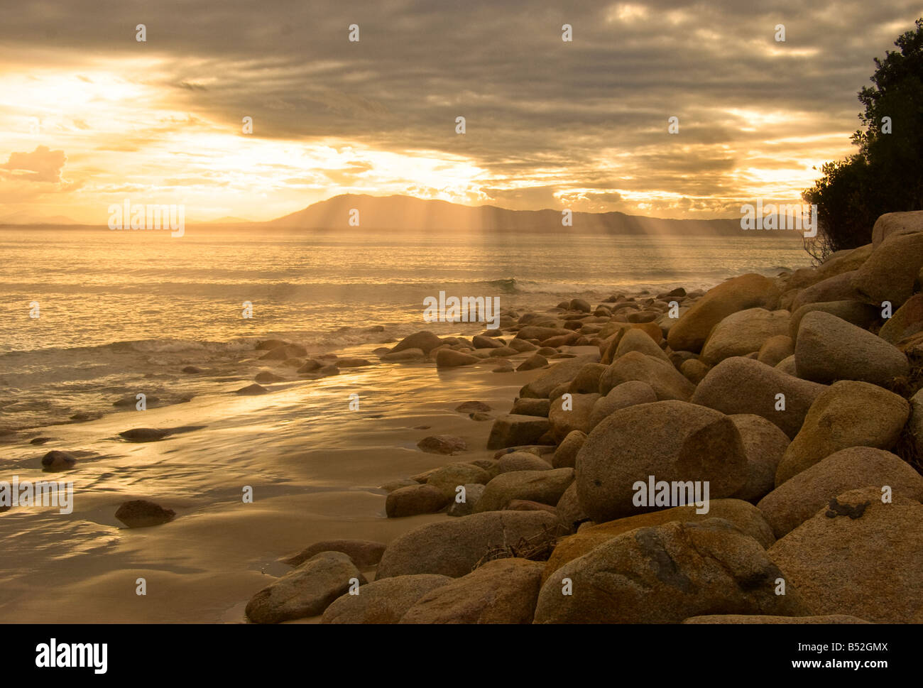 a beautiful beach at sunrise with rays of light Stock Photo - Alamy