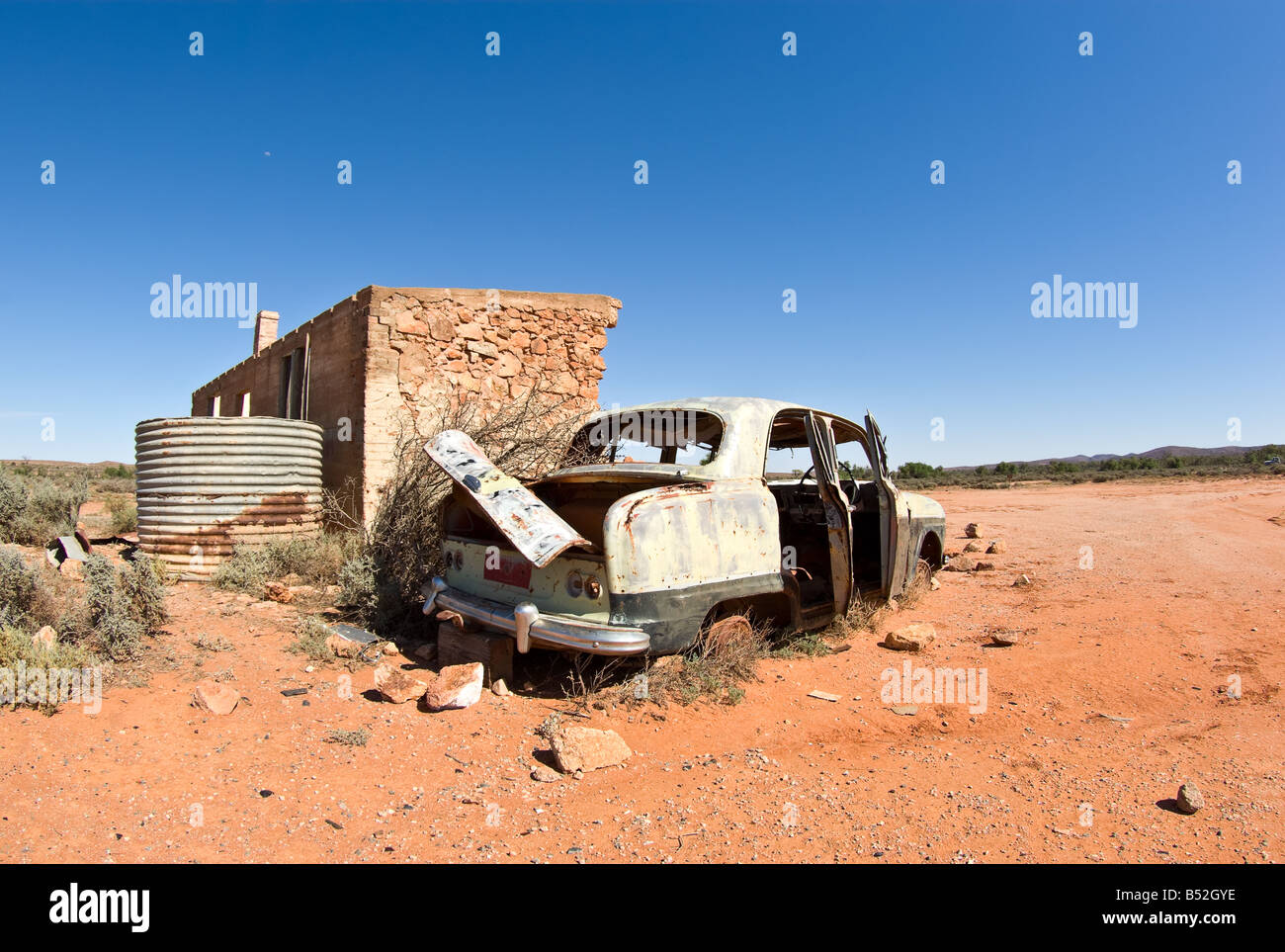 great image of an old car rusting away in the desert Stock Photo - Alamy