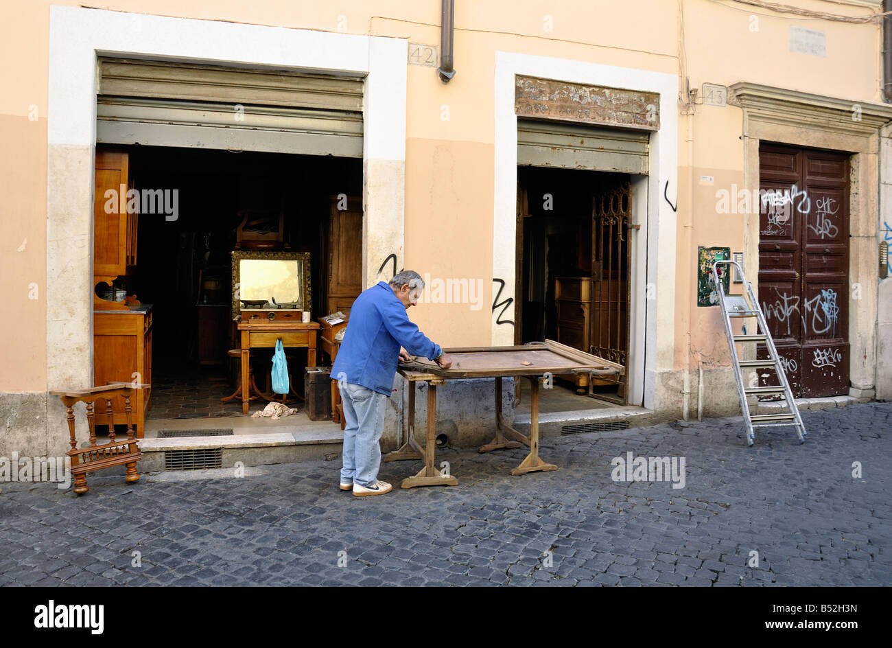 A Roman man restores an antique mirror in a Trastevere workshop in Rome ...