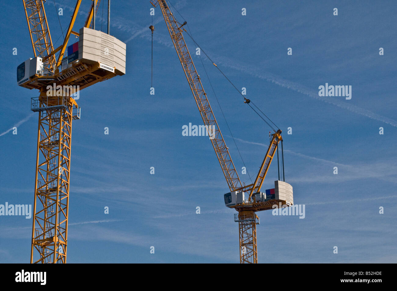 Two steel civil engineering cranes high up over a building site Stock ...