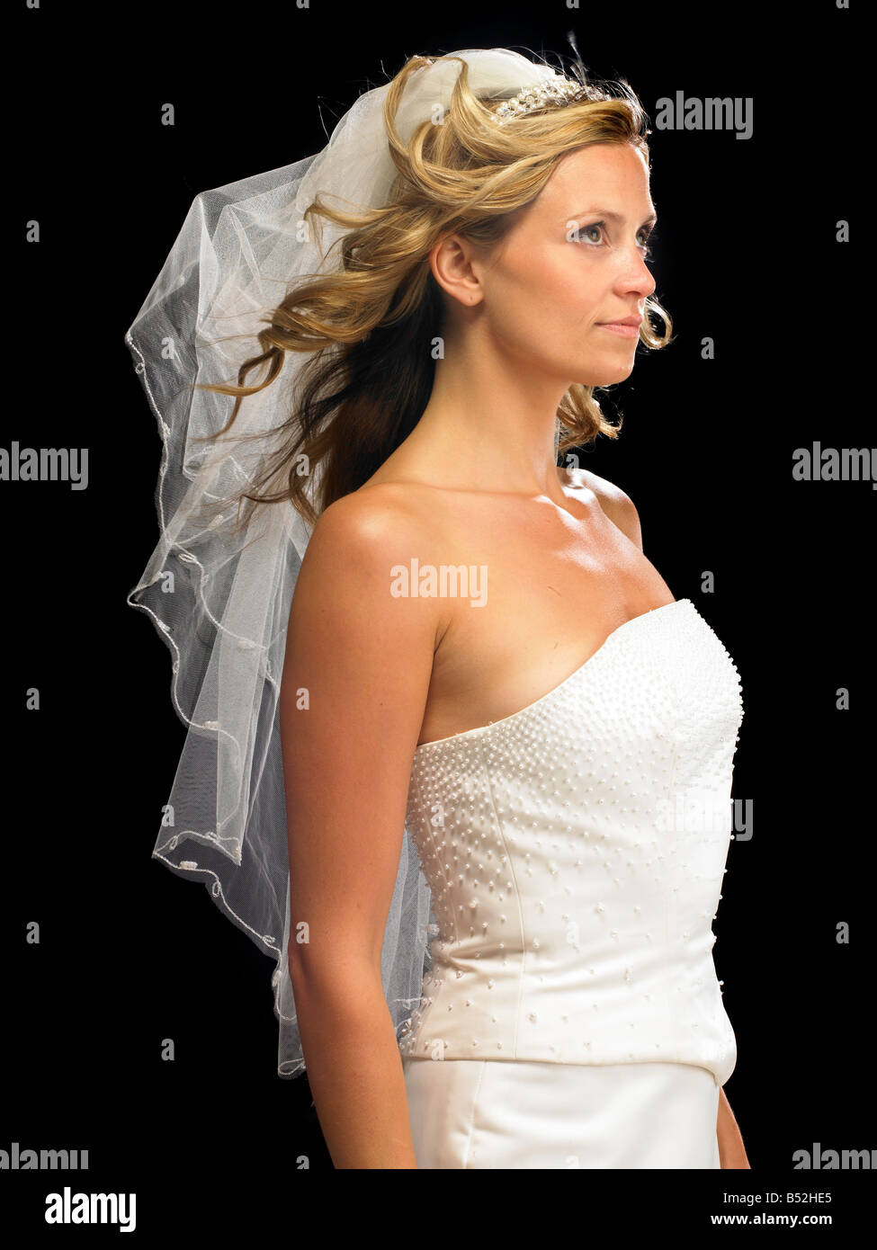 Side view of bride playing and her veil in studio Stock Photo - Alamy