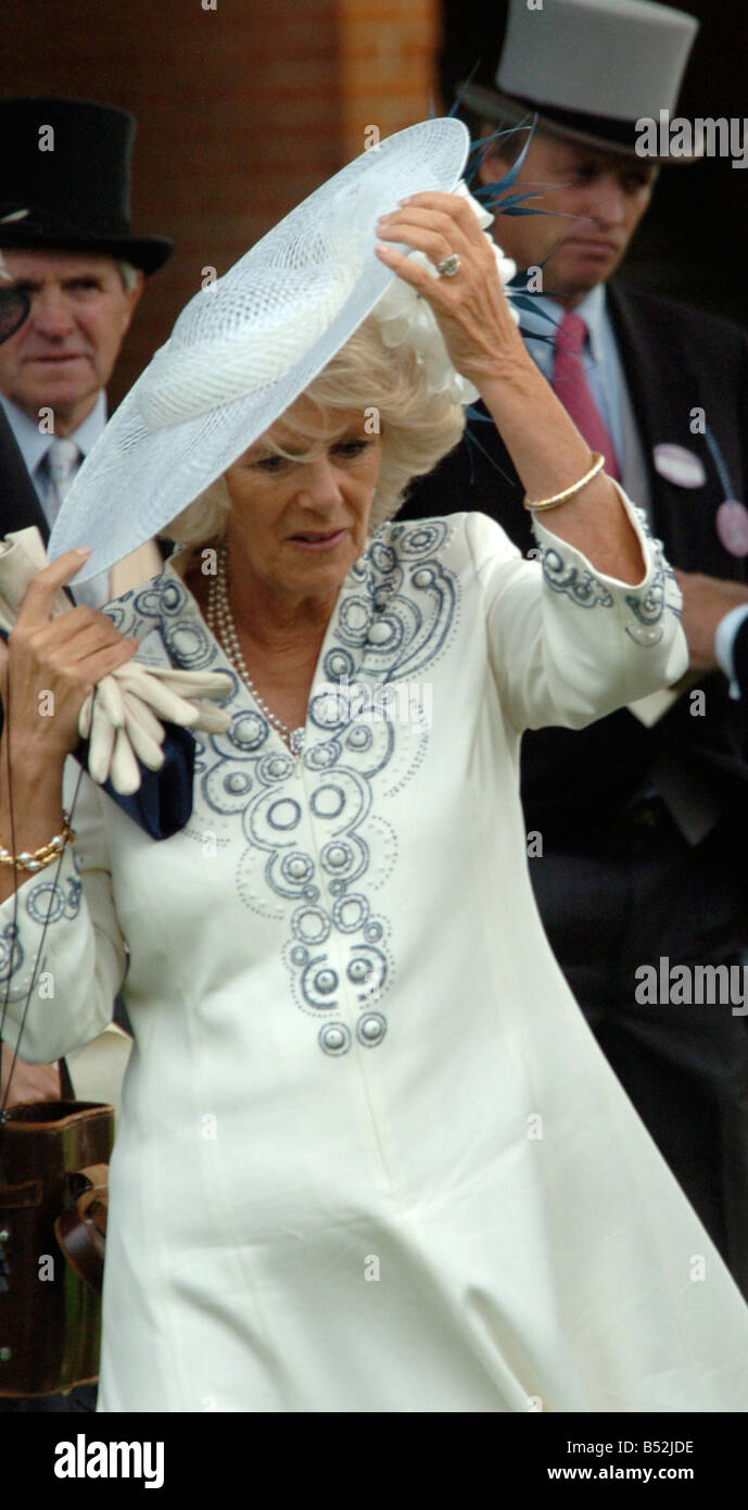 Camilla, Duchess of Cornwall holds her hat as she walks on a windy day ...