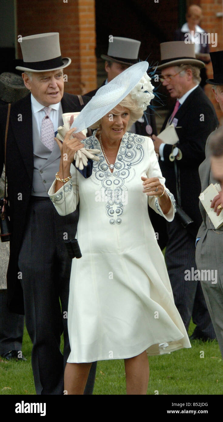 Camilla, Duchess of Cornwall holds her hat as she walks on a windy day ...