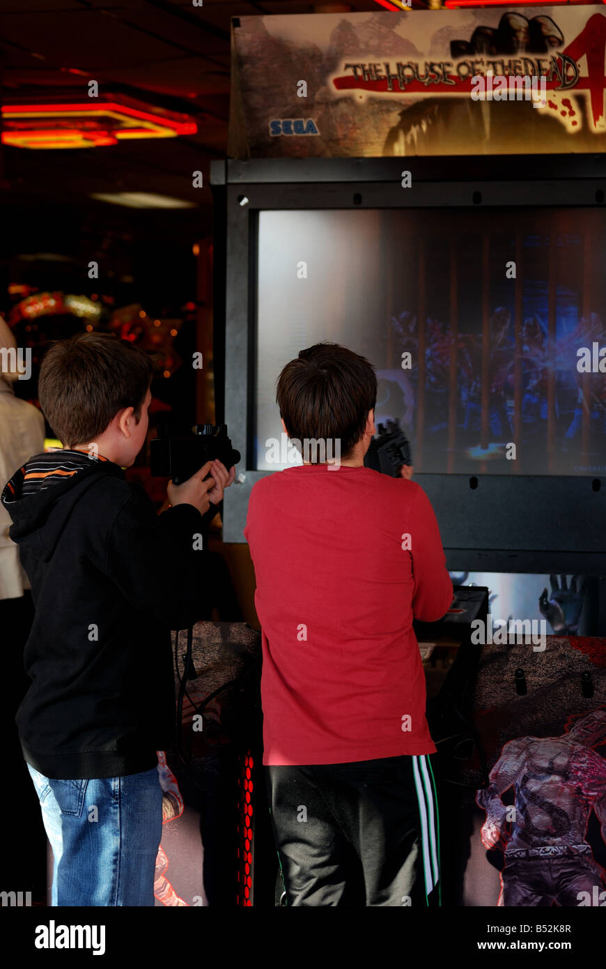 two kids playing shoot em up game Stock Photo - Alamy
