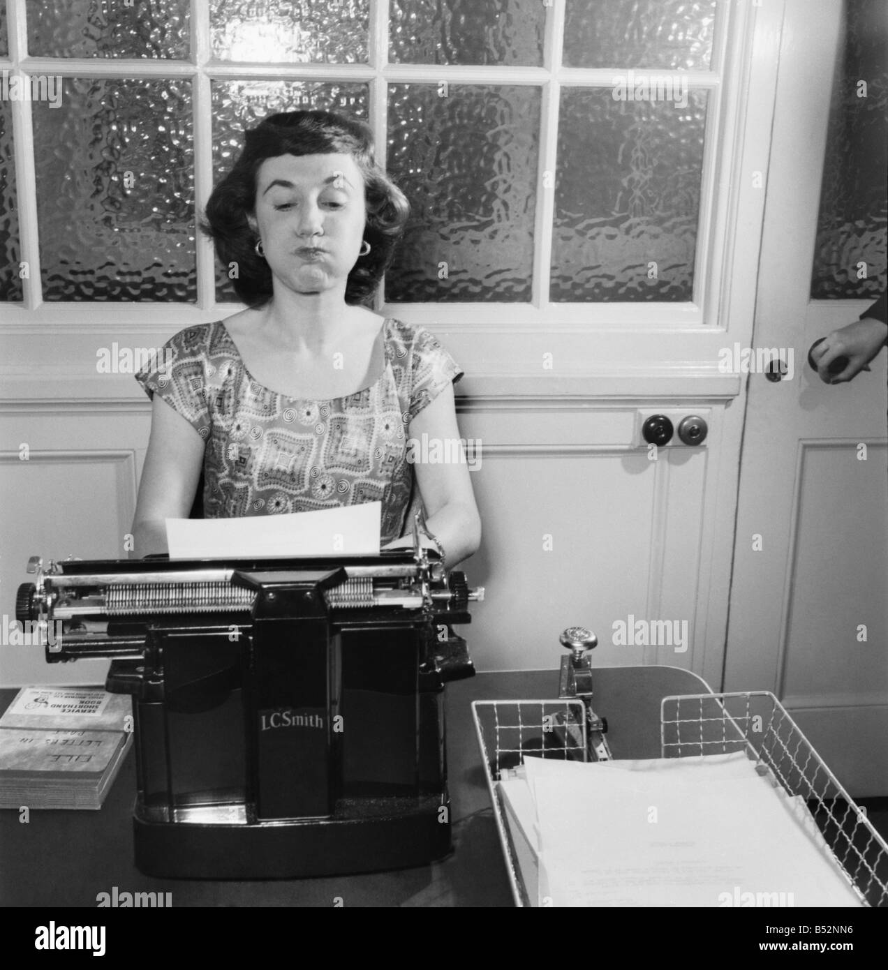 Bored Secretary Puffs at her Cheeks. July 1953 D3421 Stock Photo - Alamy